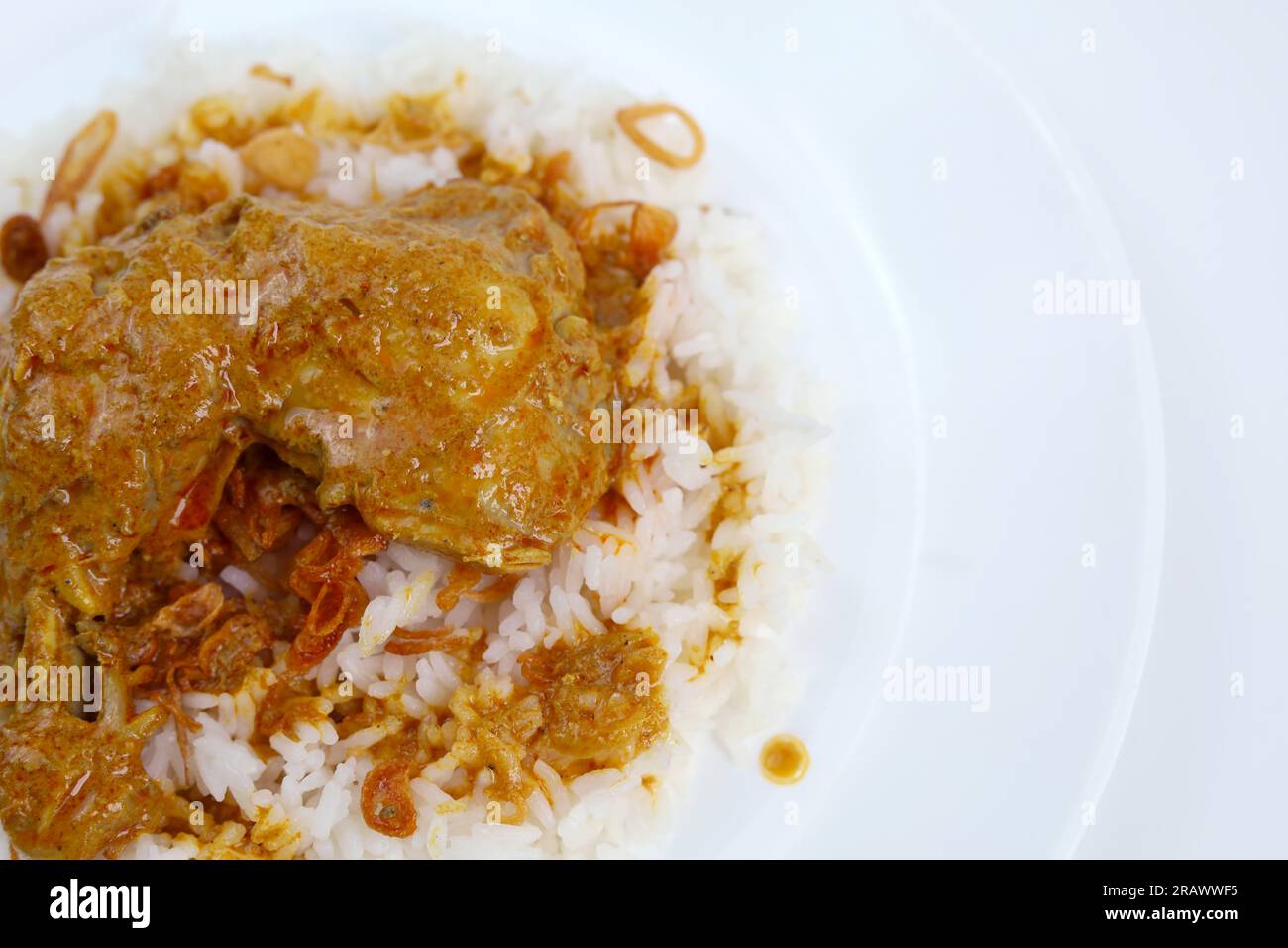 Top view a plate of warm white rice topped with chicken curry. Padang ...