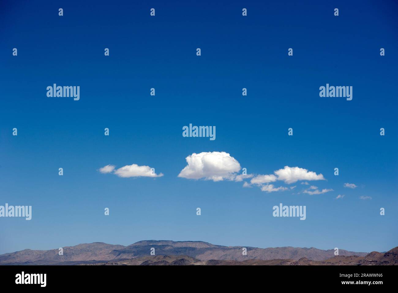 Small puffy clouds viewed through the windshield of a car heading north ...