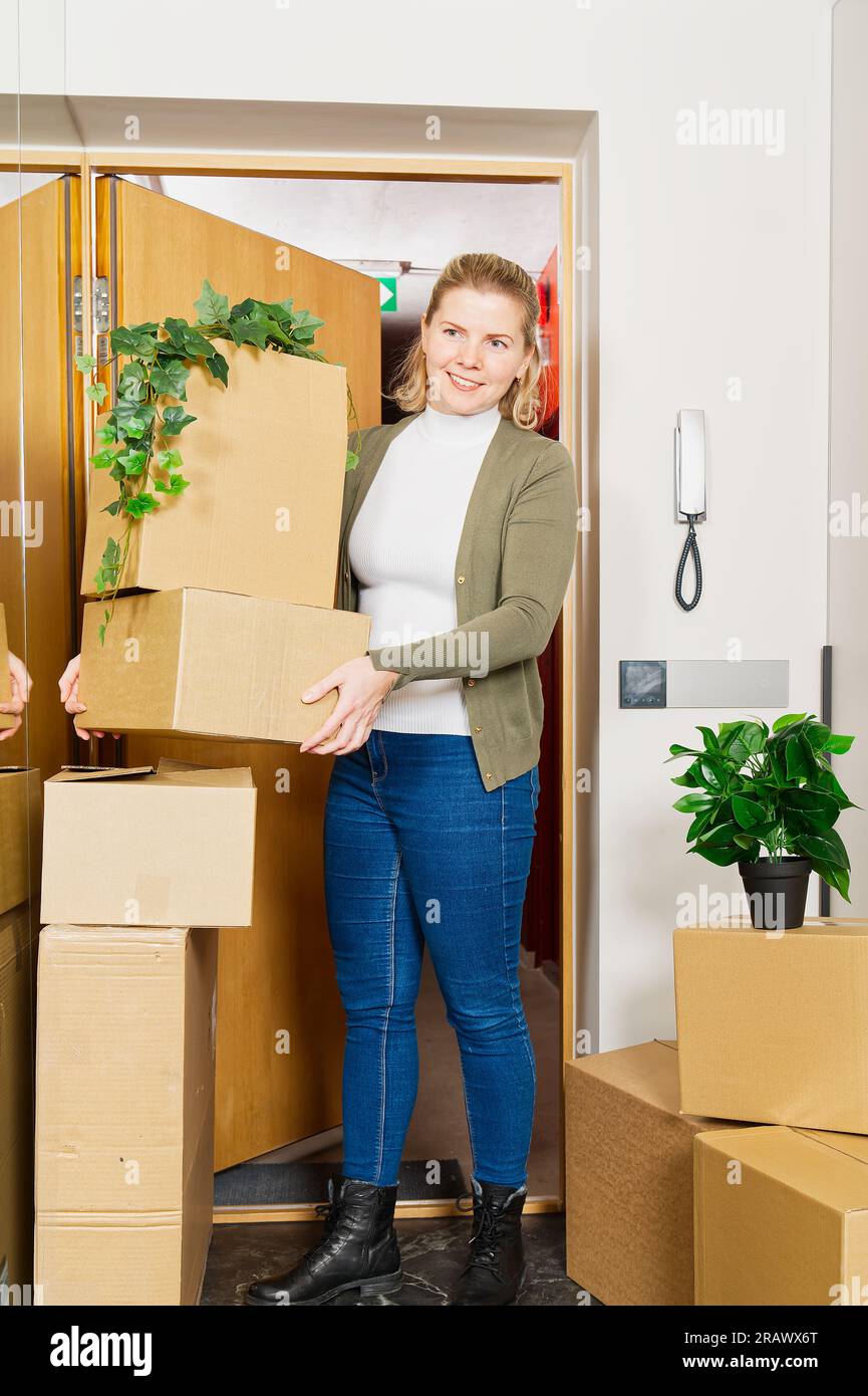 Happy young single woman moving to new home. Having fun in moving day ...