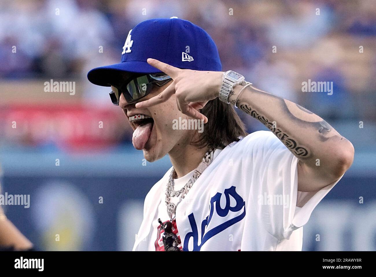 Rapper Peso Pluma gestures to fans before throwing out the ceremonial ...