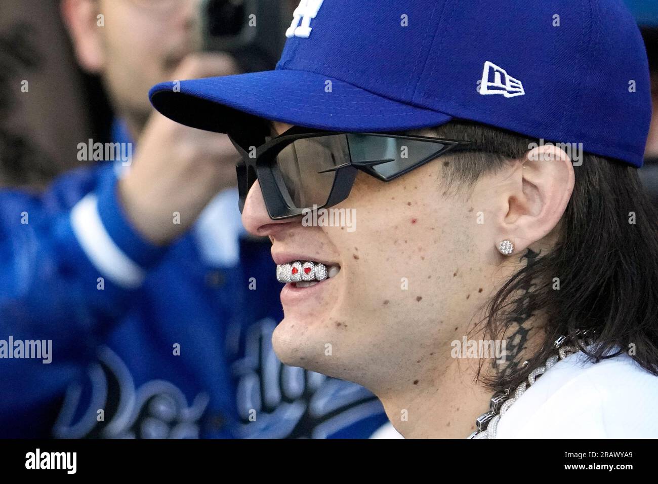 Rapper Peso Pluma smiles as he talks to starting pitcher Julio Urias ...