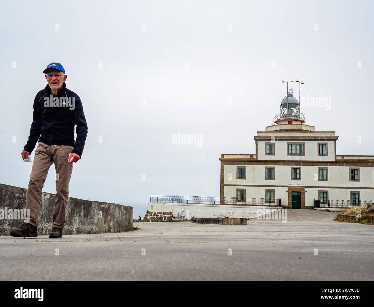 An old pilgrim is seen leaving the lighthouse. The Camino de Santiago ...