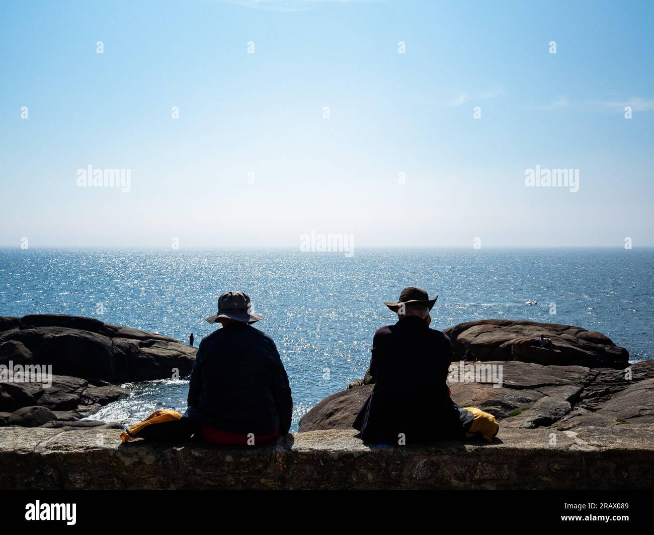 Two pilgrims are seen resting in front of the sea. The Camino de ...