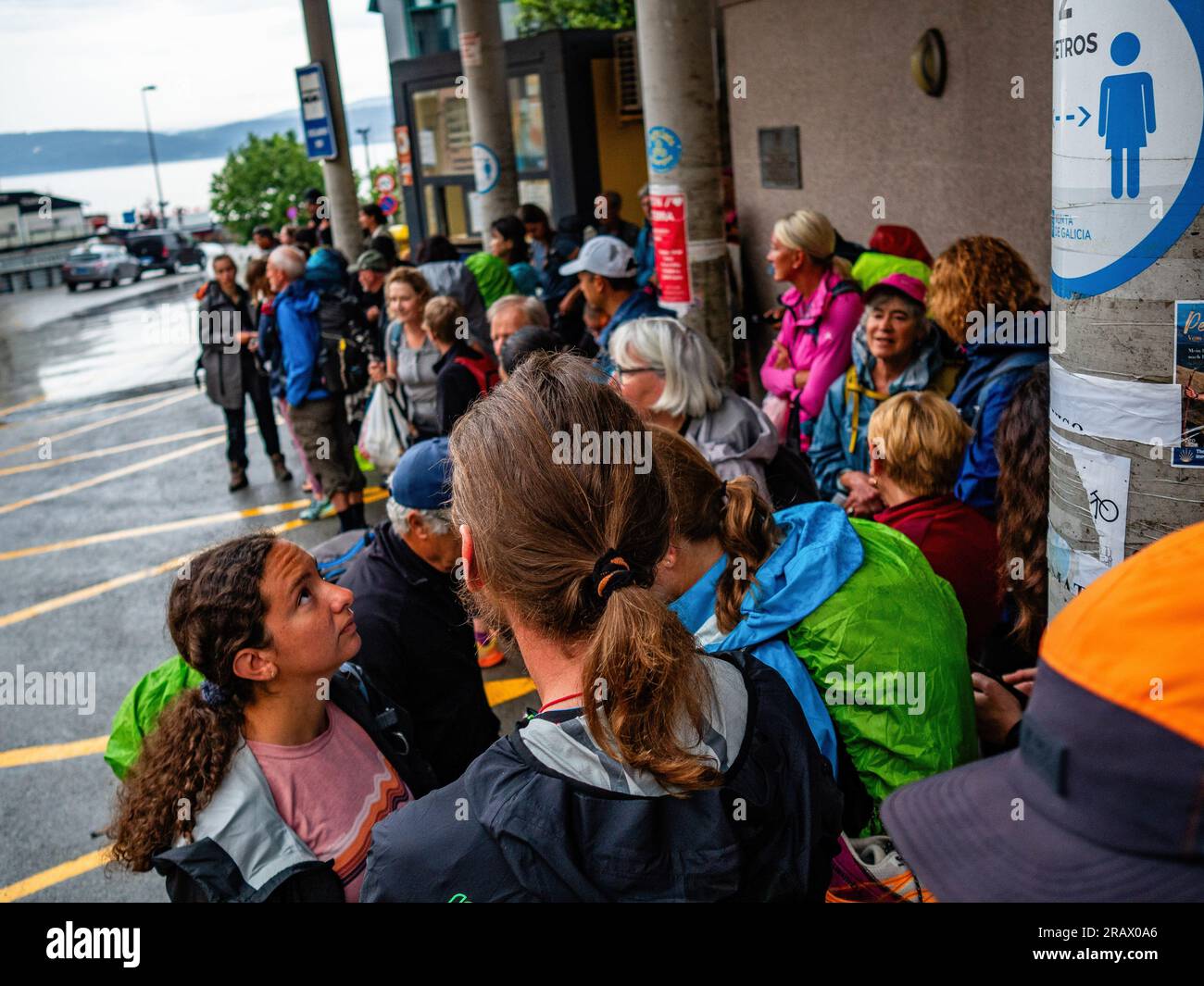 Pilgrims are seen waiting for the bus back to Santiago. The Camino de ...