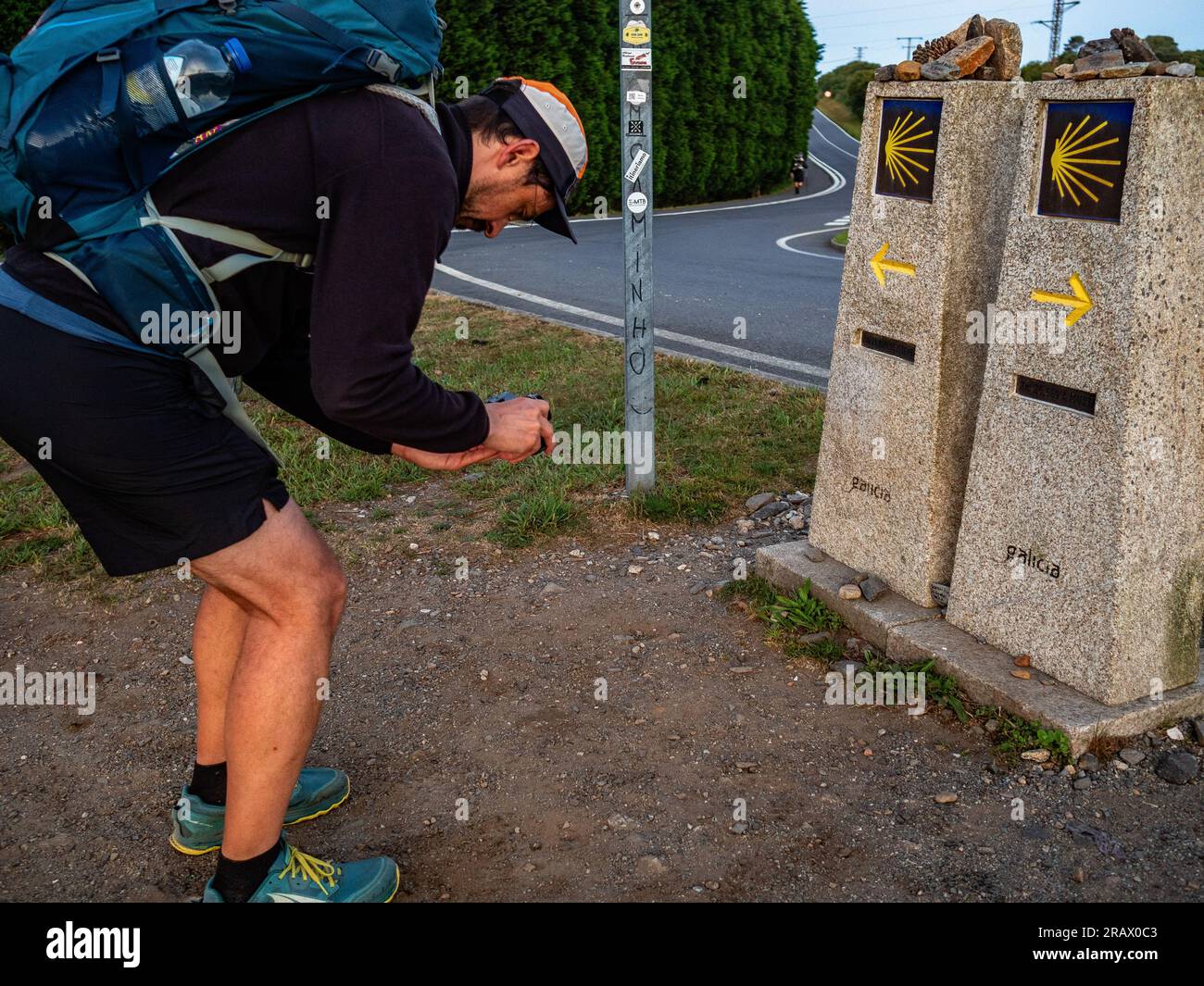 A hiker is seen taking a photo of the two stone trademarks that mark ...