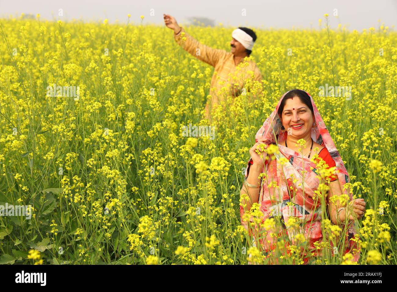 Happy rural Indian family standing in a mustard field. Happy to see the ...