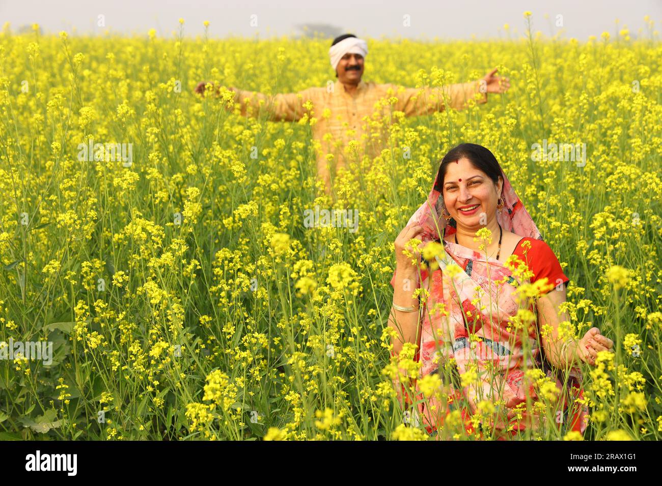Happy rural Indian family standing in a mustard field. Happy to see the ...