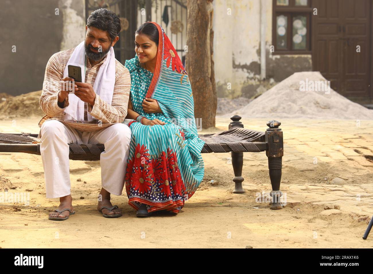Happy rural Indian villager family of husband and wife sitting together ...