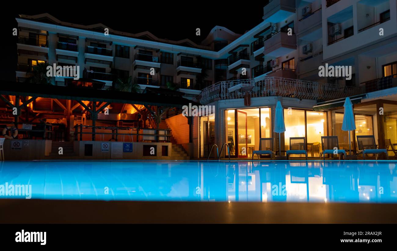 Beautiful hotel illuminated at night near the blue pool Stock Photo - Alamy