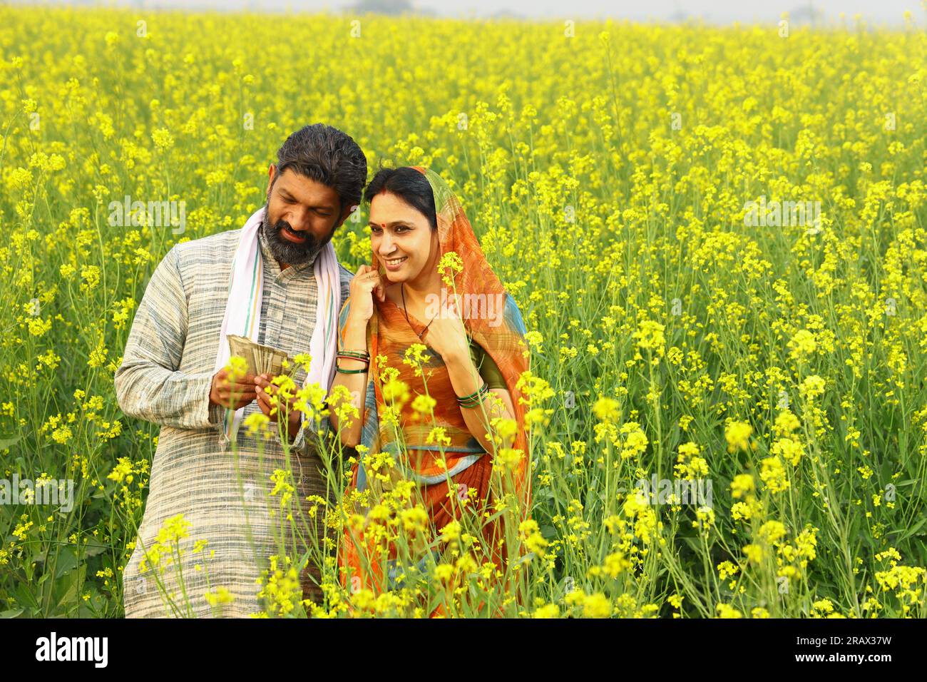 Happy rural Indian family standing in a mustard field. Happy to see the ...