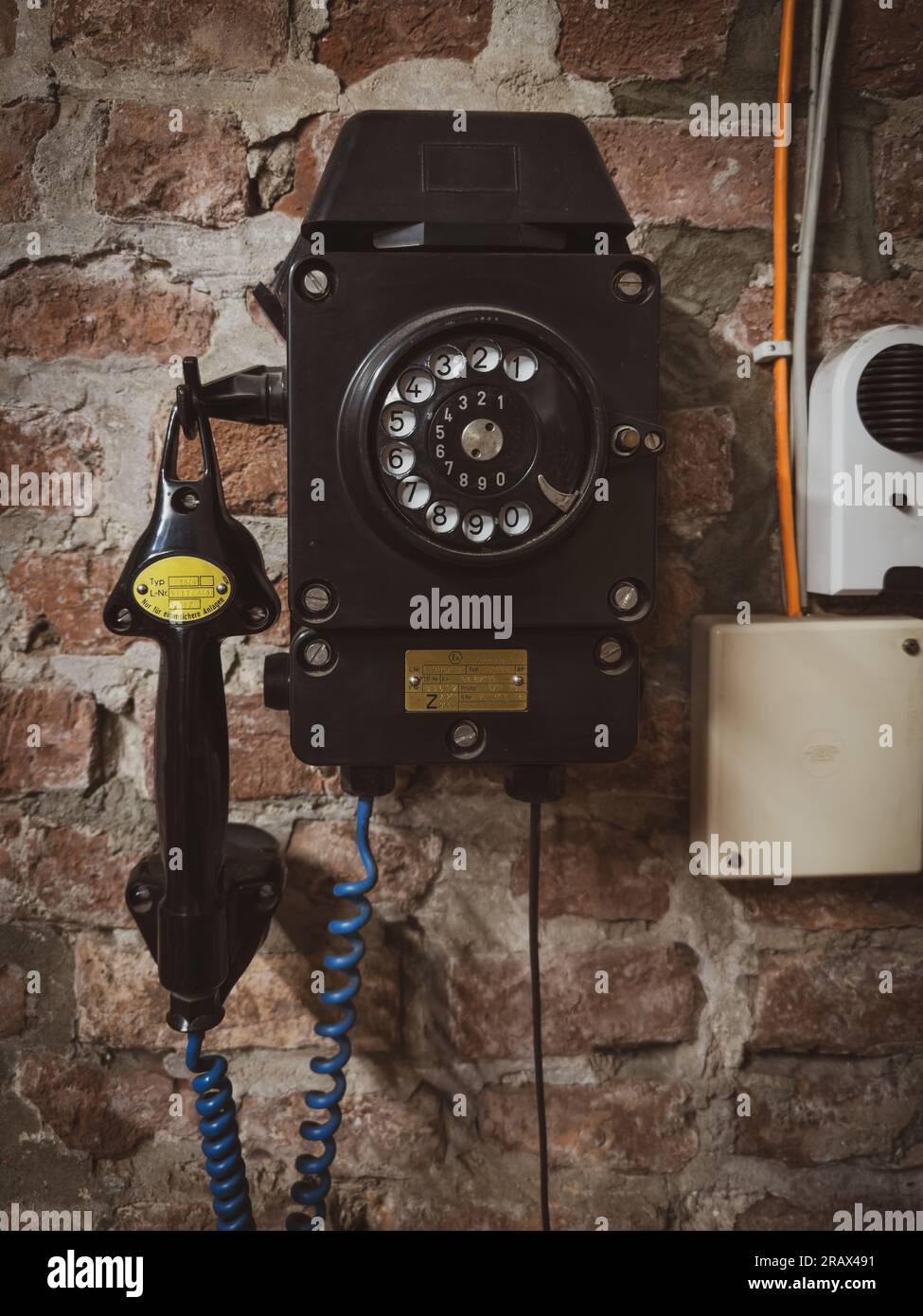 on the wall hangs an old dial telephone Stock Photo - Alamy