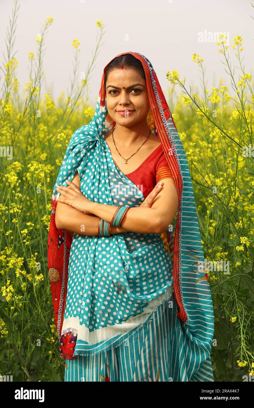 Happy rural Indian women standing in a mustard field enjoying the ...