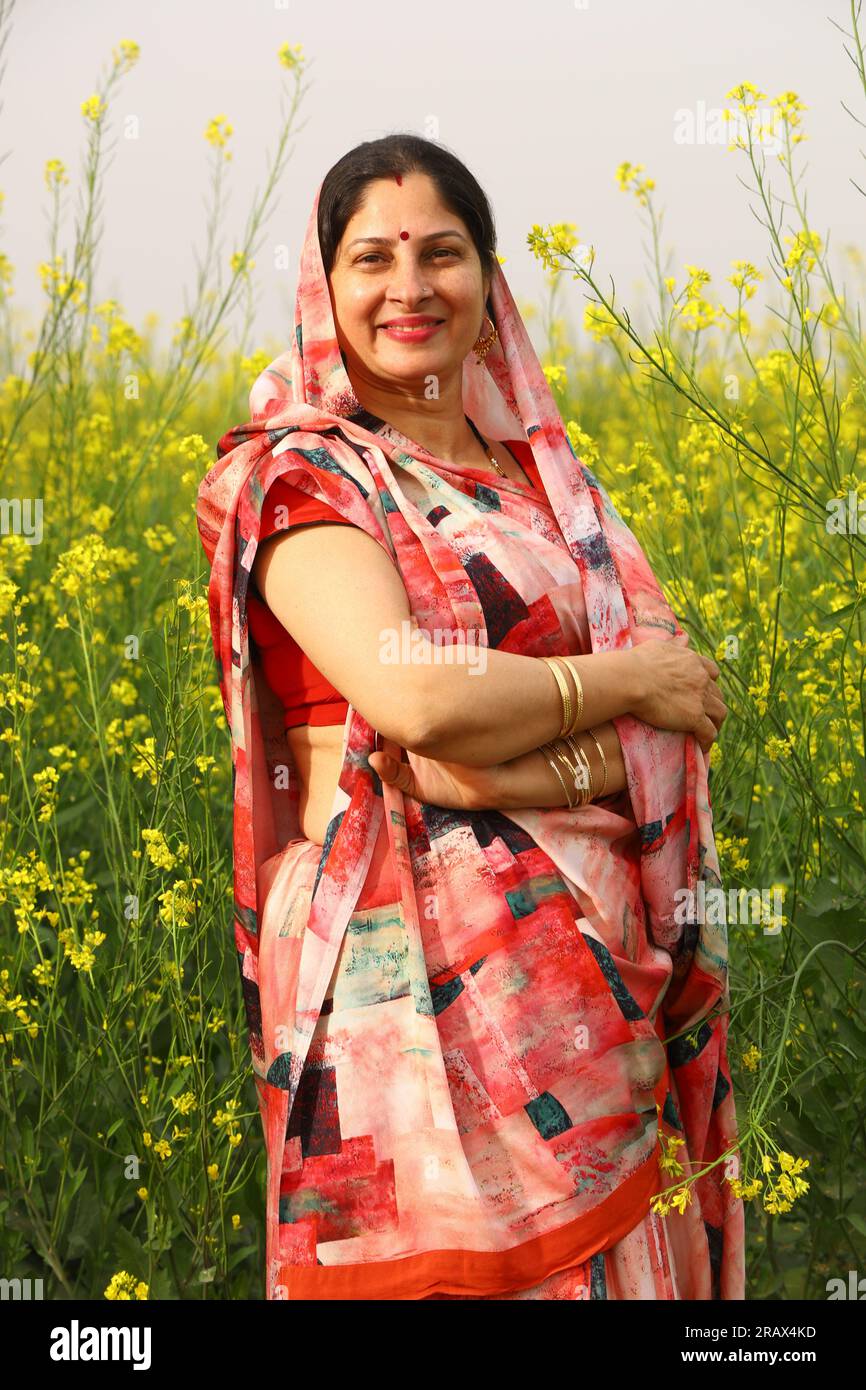 Happy rural Indian women standing in a mustard field enjoying the ...