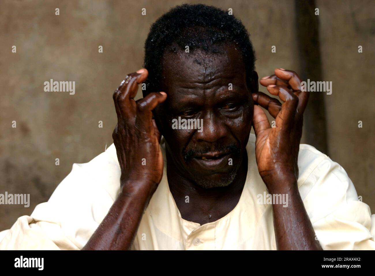 Muslim male in Chad cleaning his ears during wudu or washing before ...