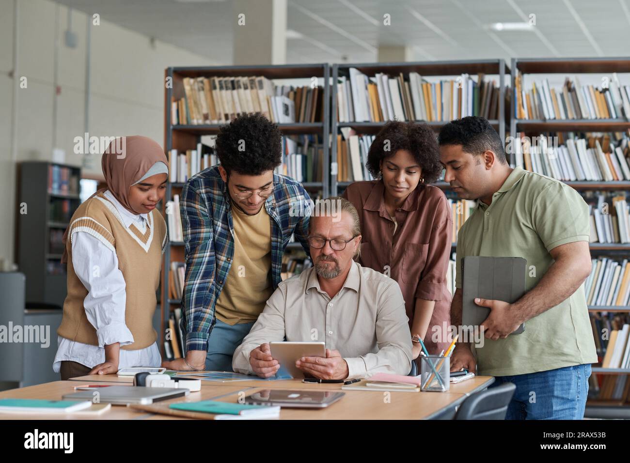 Teacher having lesson with migrant students, they watching presentation ...