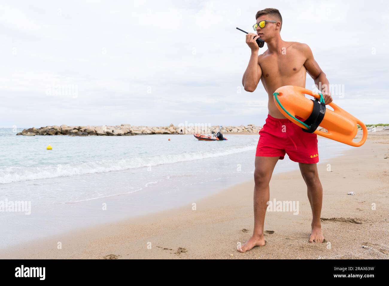 Photo with copy space of a Lifeguard using the radio while walking ...