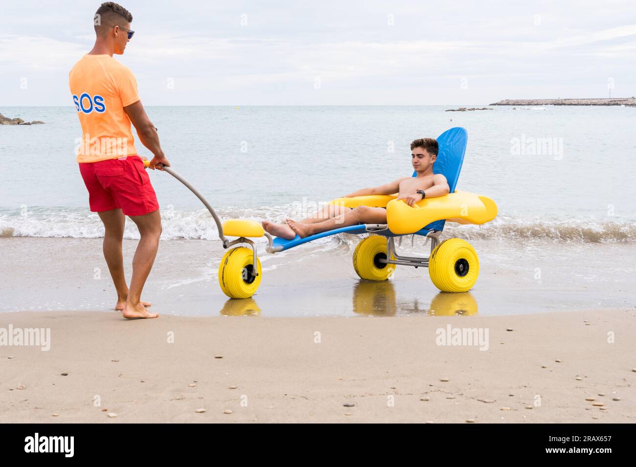 lifeguards rescuing an injured man on the beach Stock Photo - Alamy