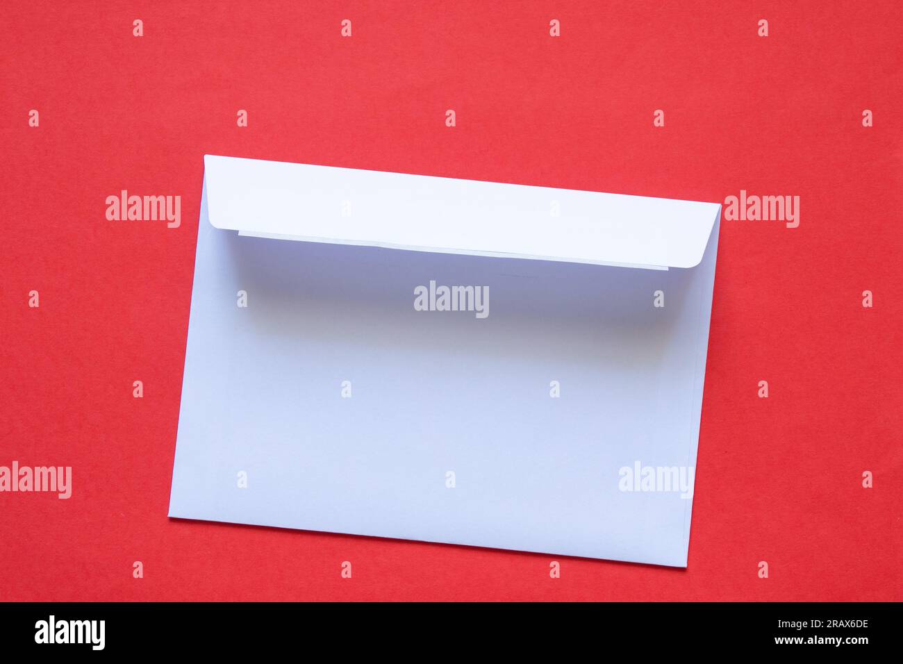 paper white mail envelope lies on a red background close-up Stock Photo ...