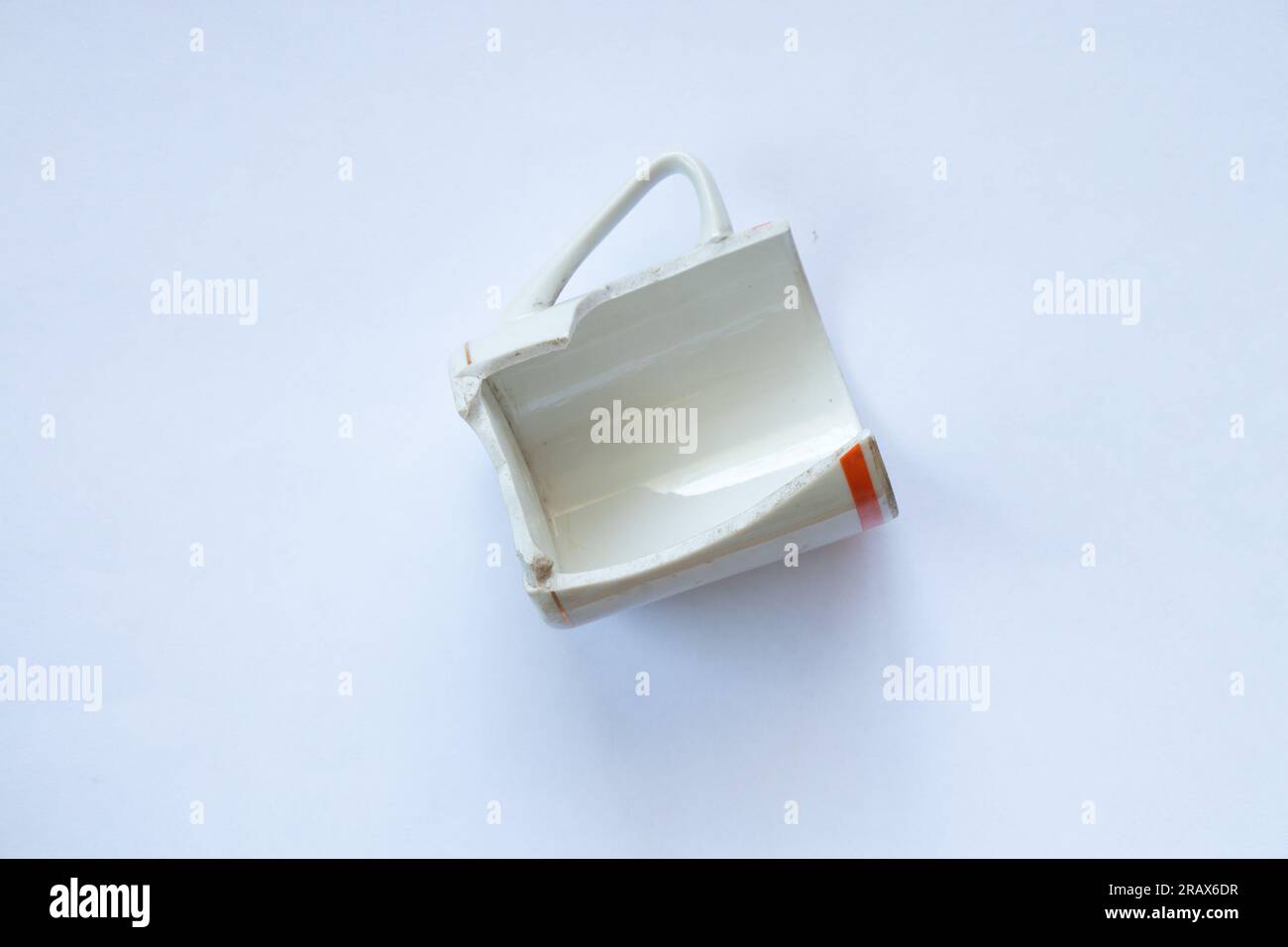 white broken cup on white background close up Stock Photo - Alamy