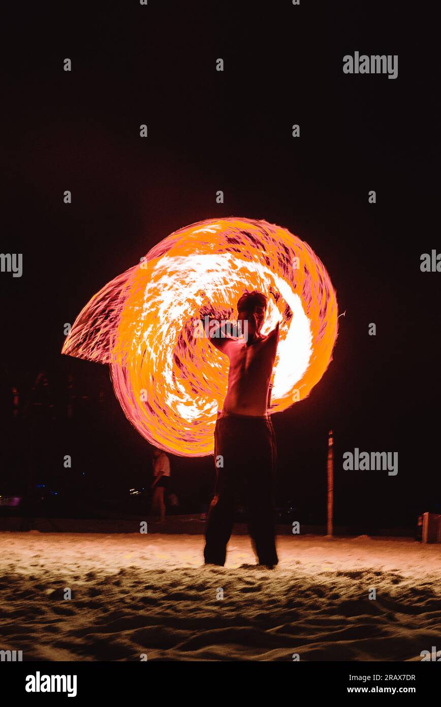 A mesmerizing fire dancer gracefully manipulates ignited balls ...