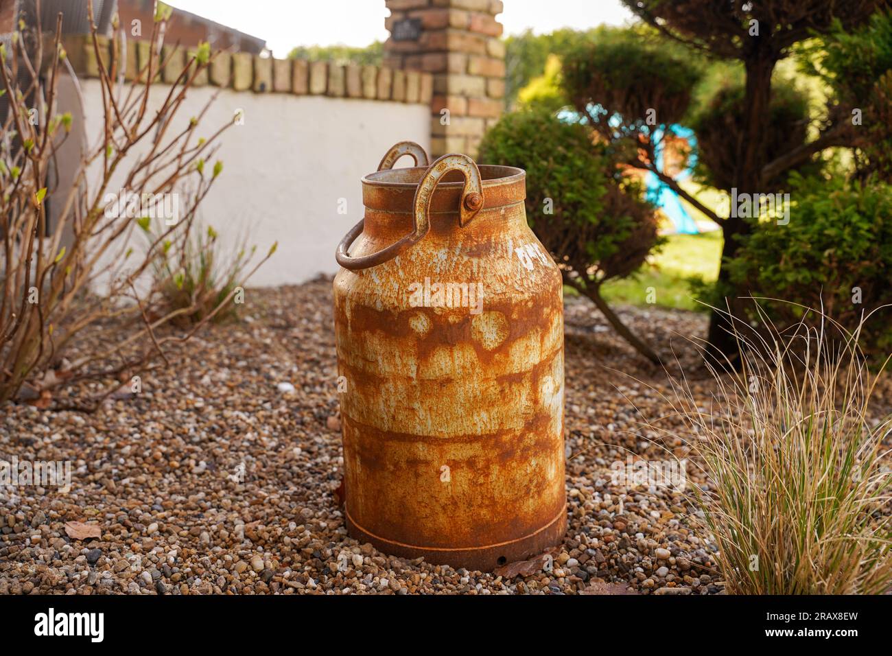 An old rusty container in the garden. Reuse of old things. An old can ...