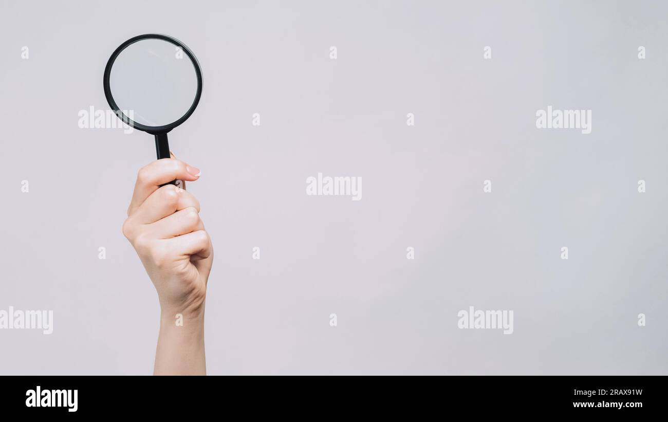 Searching glass zooming loupe female hand examine Stock Photo - Alamy