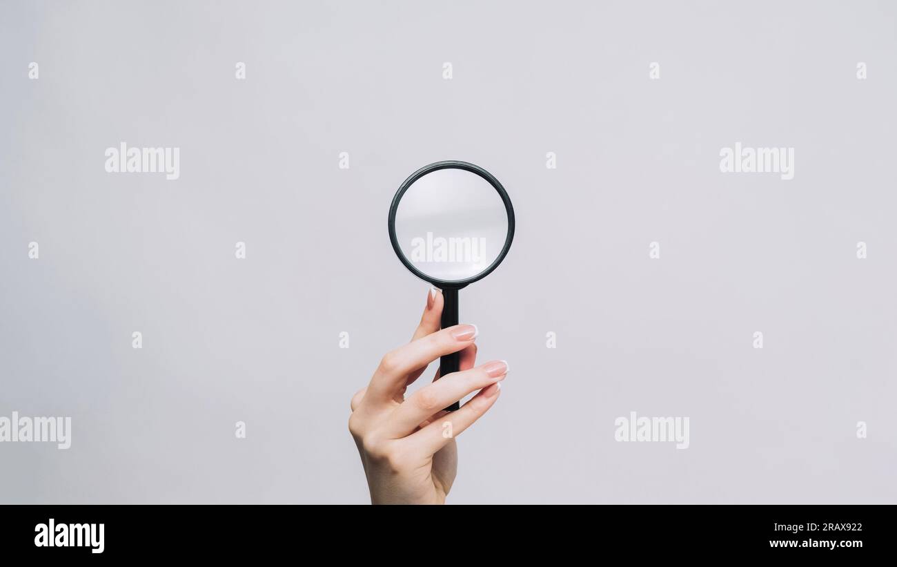 Magnifying glass zooming tool woman hand exploring Stock Photo - Alamy