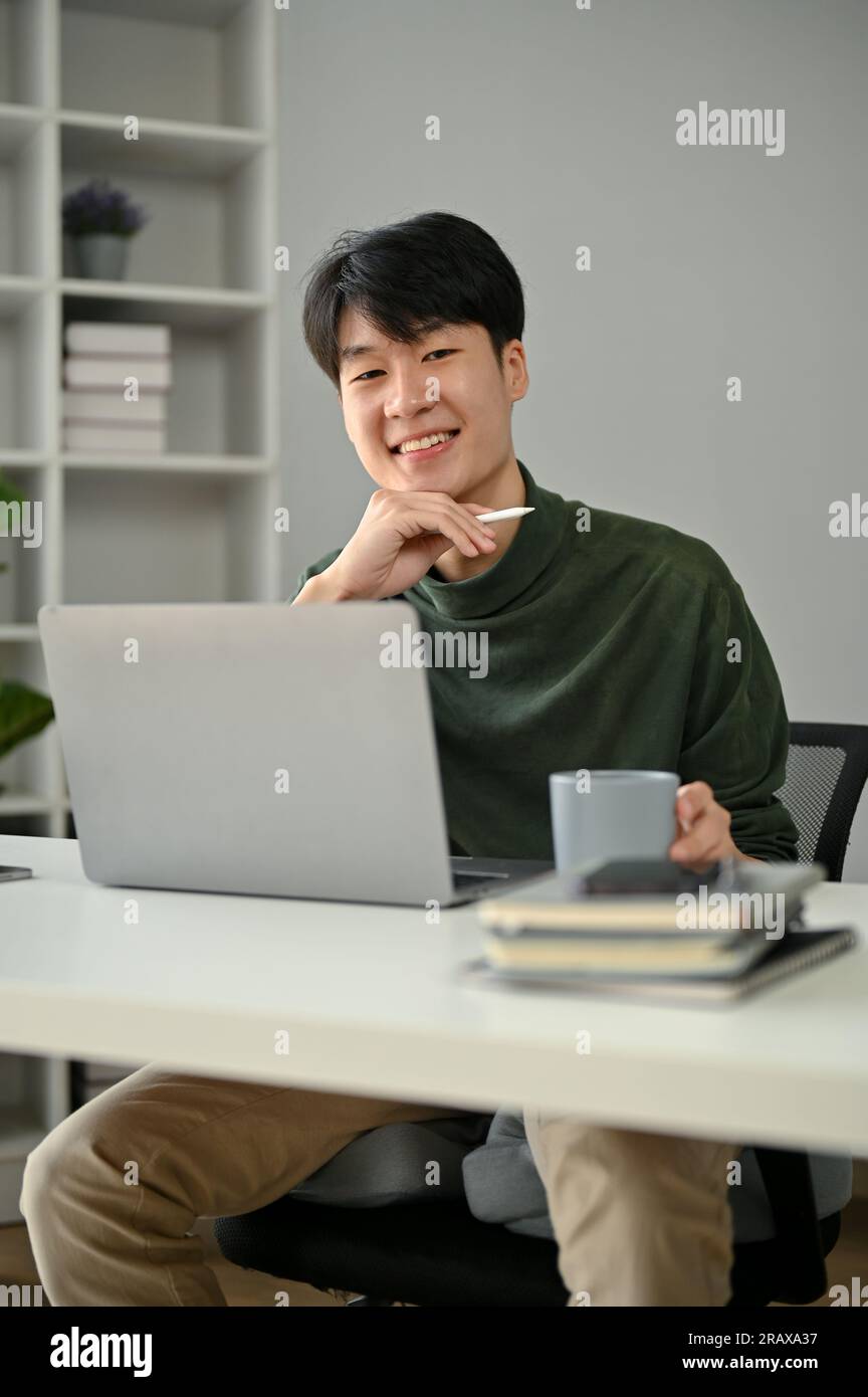 A portrait of a handsome and smiling young Asian man in causal clothes ...