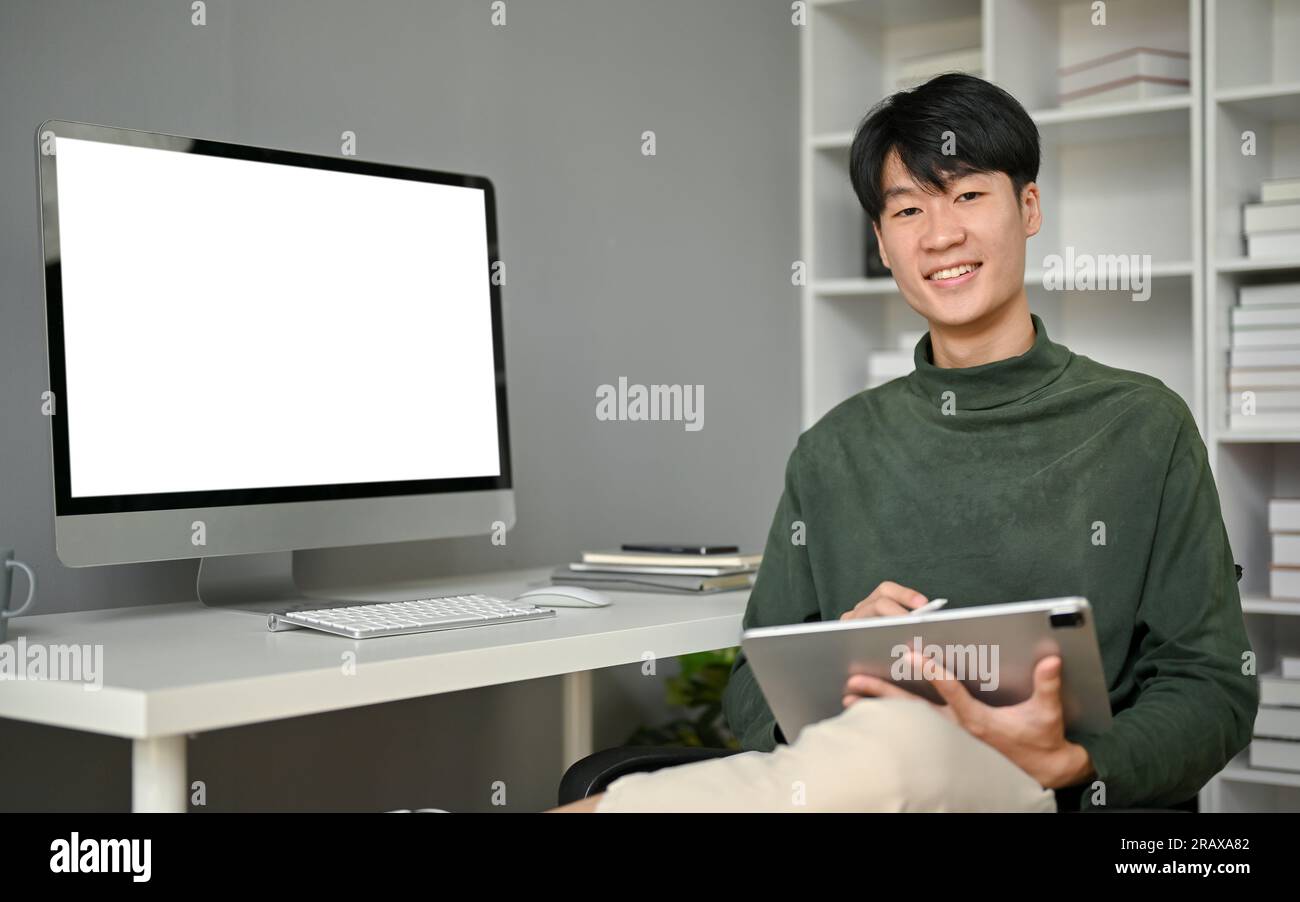 A portrait of a handsome and smiling young Asian man in casual clothes ...