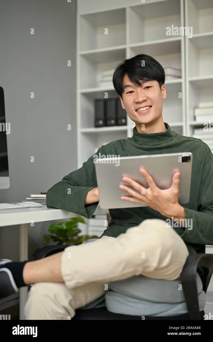 A portrait of a handsome and smiling young Asian man in casual clothes ...