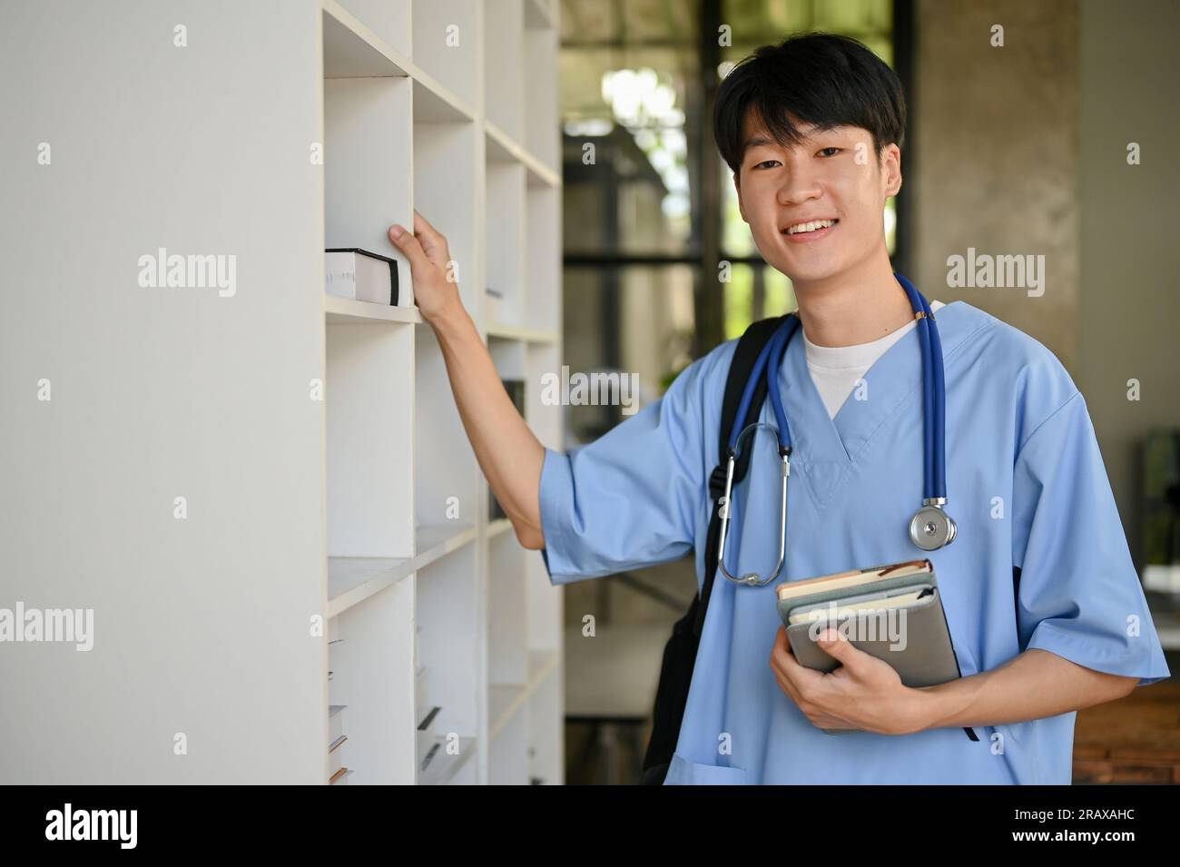 A smart and handsome young Asian male medical student in scrubs ...