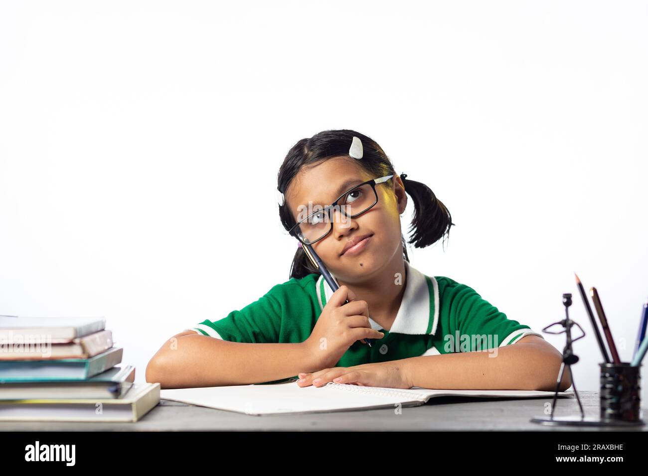 A pretty beautiful Indian girl child studying at study table and ...
