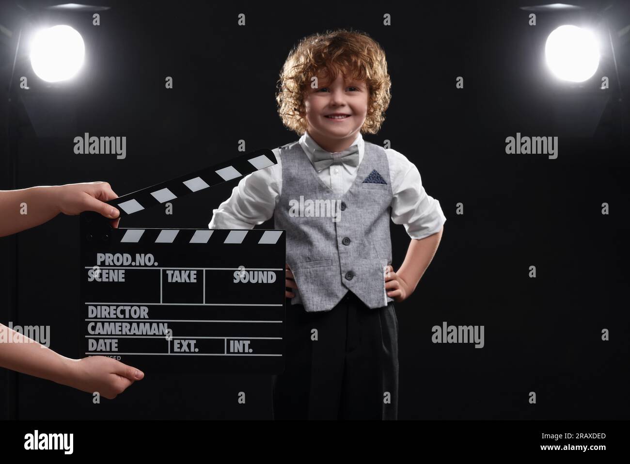 Smiling cute boy performing while second assistant camera holding ...