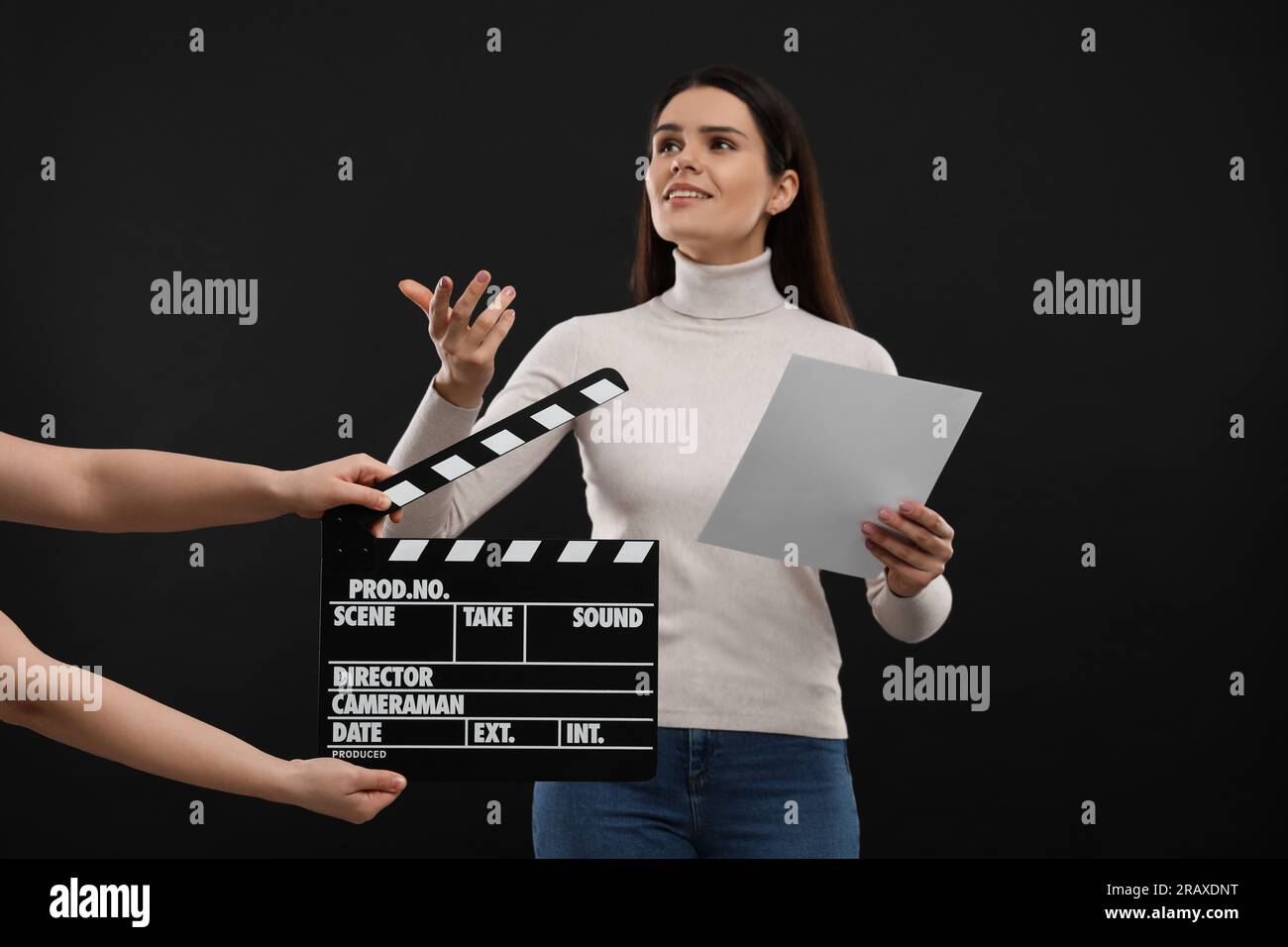 Actress performing while second assistant camera holding clapperboard ...