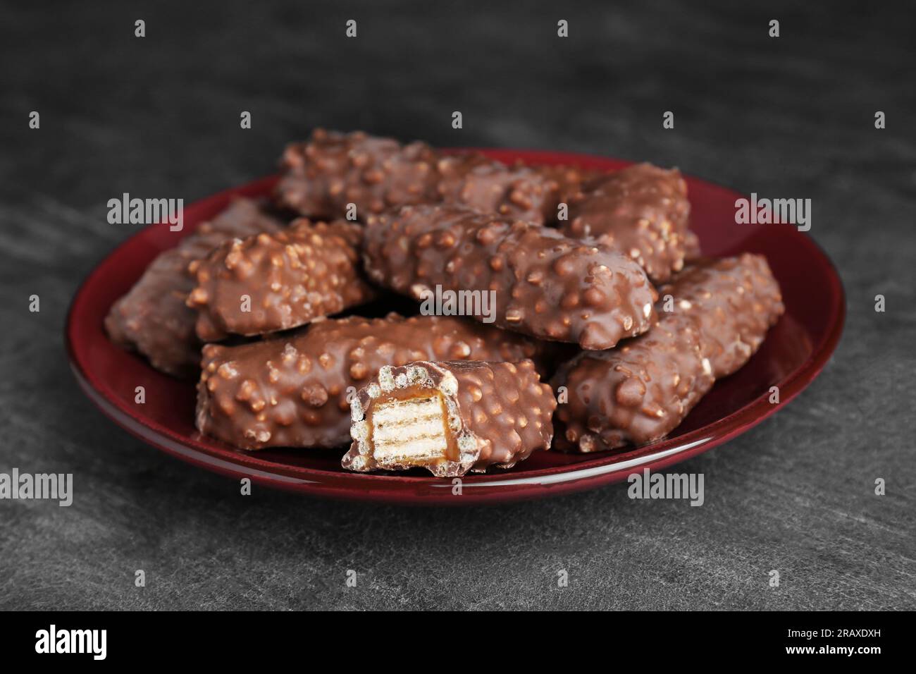 Plate of tasty chocolate bars with caramel on light grey table Stock ...