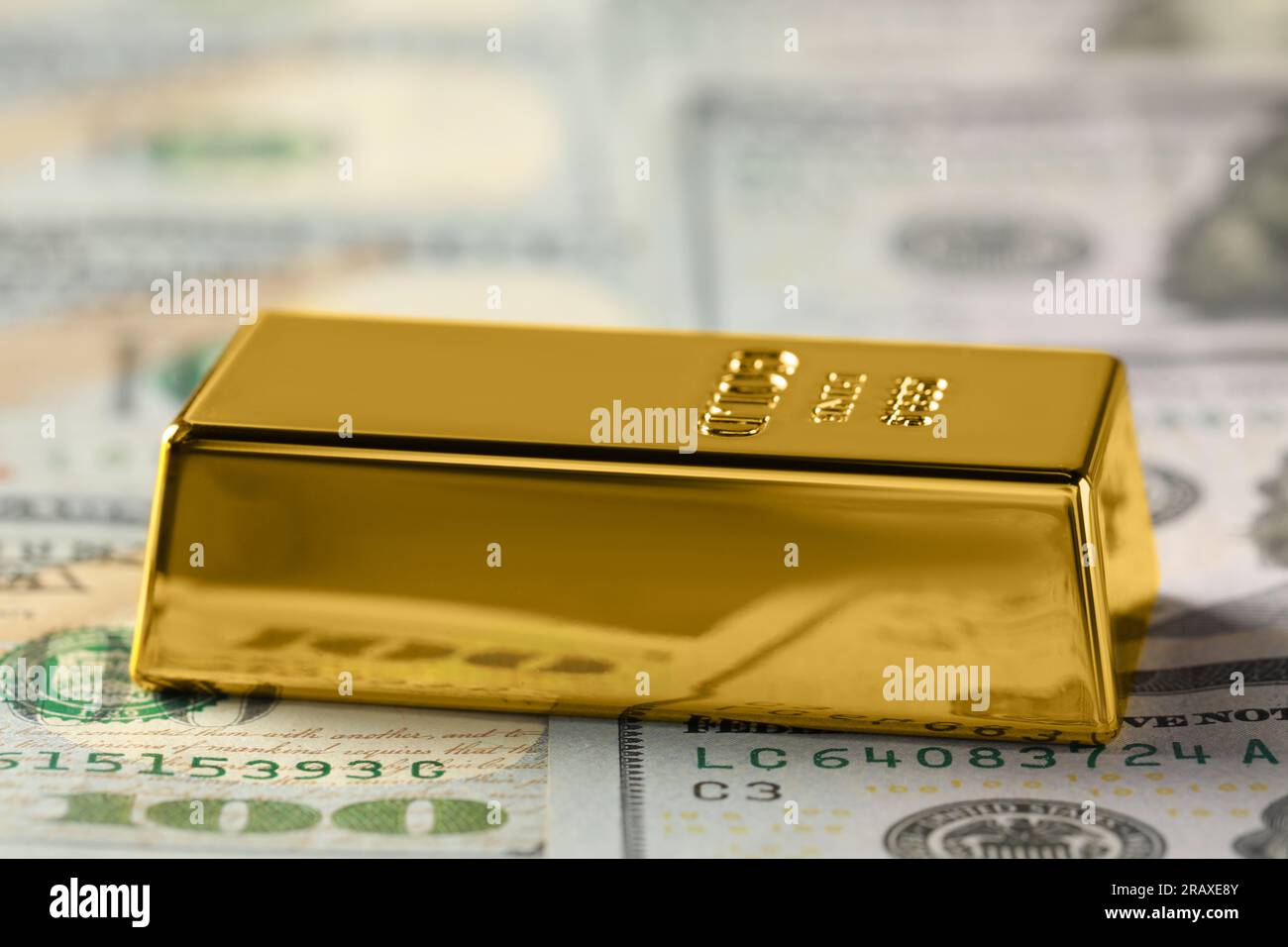 Shiny gold bar on dollar banknotes, closeup Stock Photo - Alamy