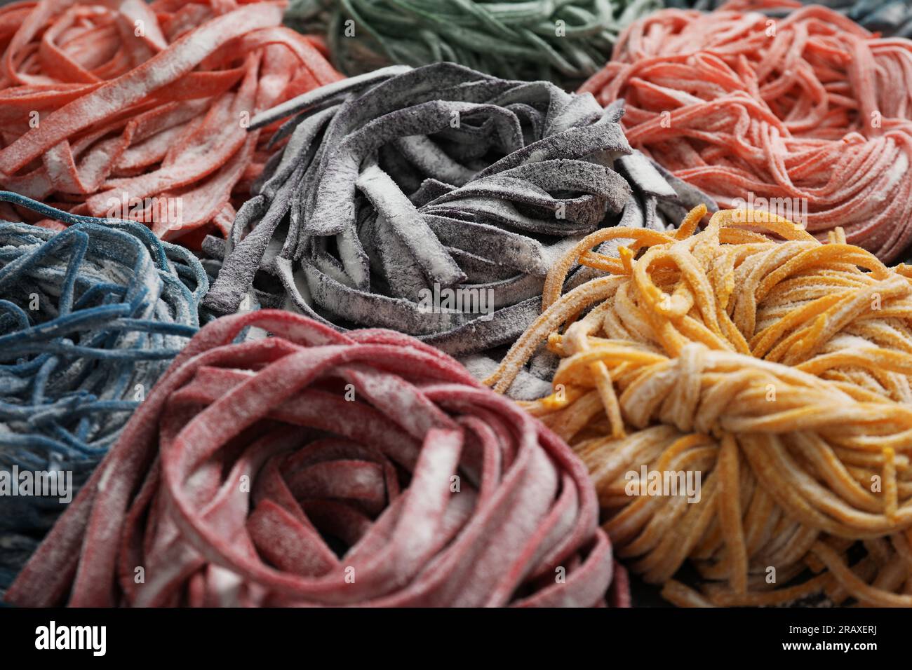 Rolled pasta painted with food colorings as background, closeup Stock ...