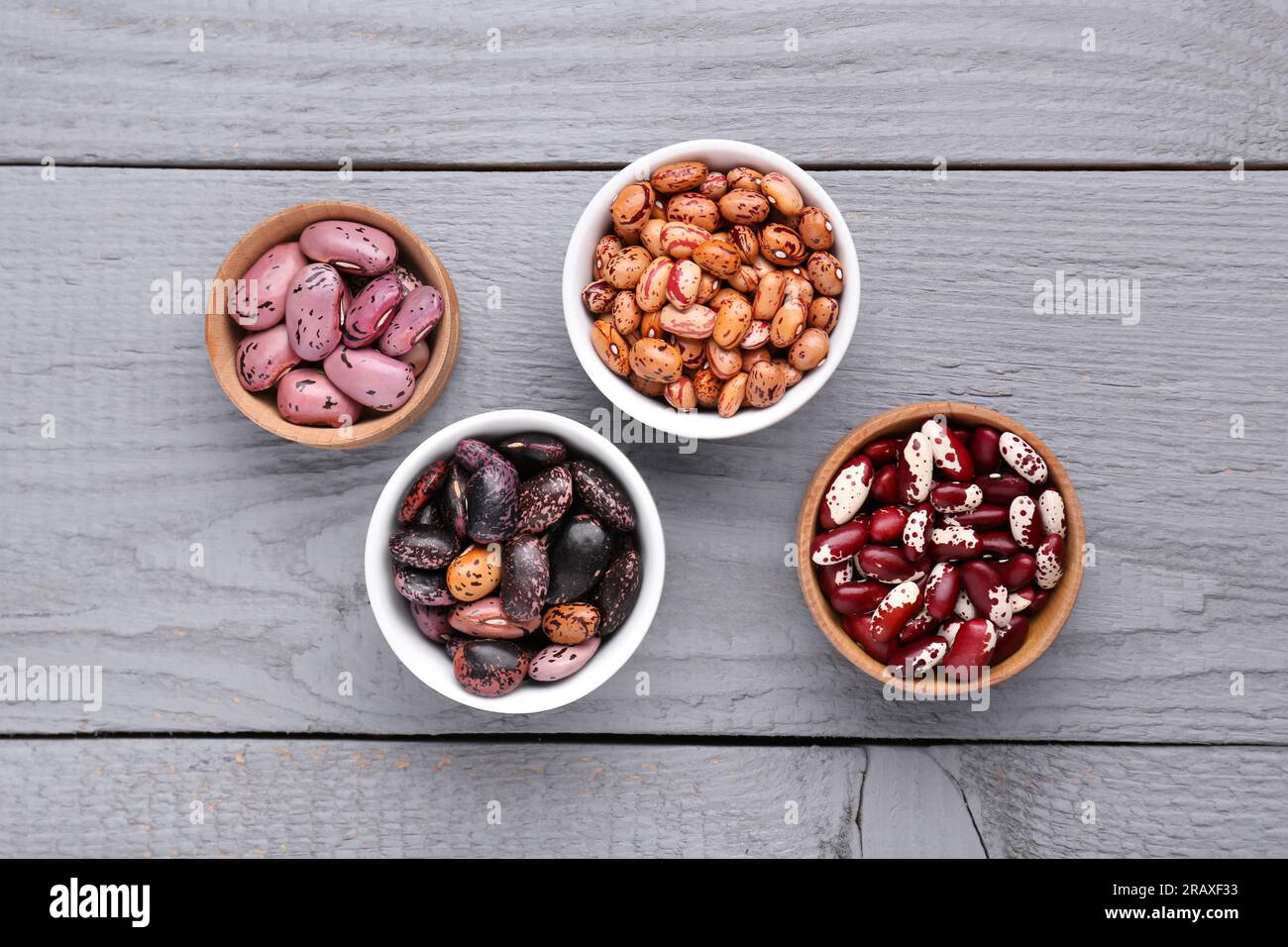 Different kinds of dry kidney beans on light grey wooden table, flat ...