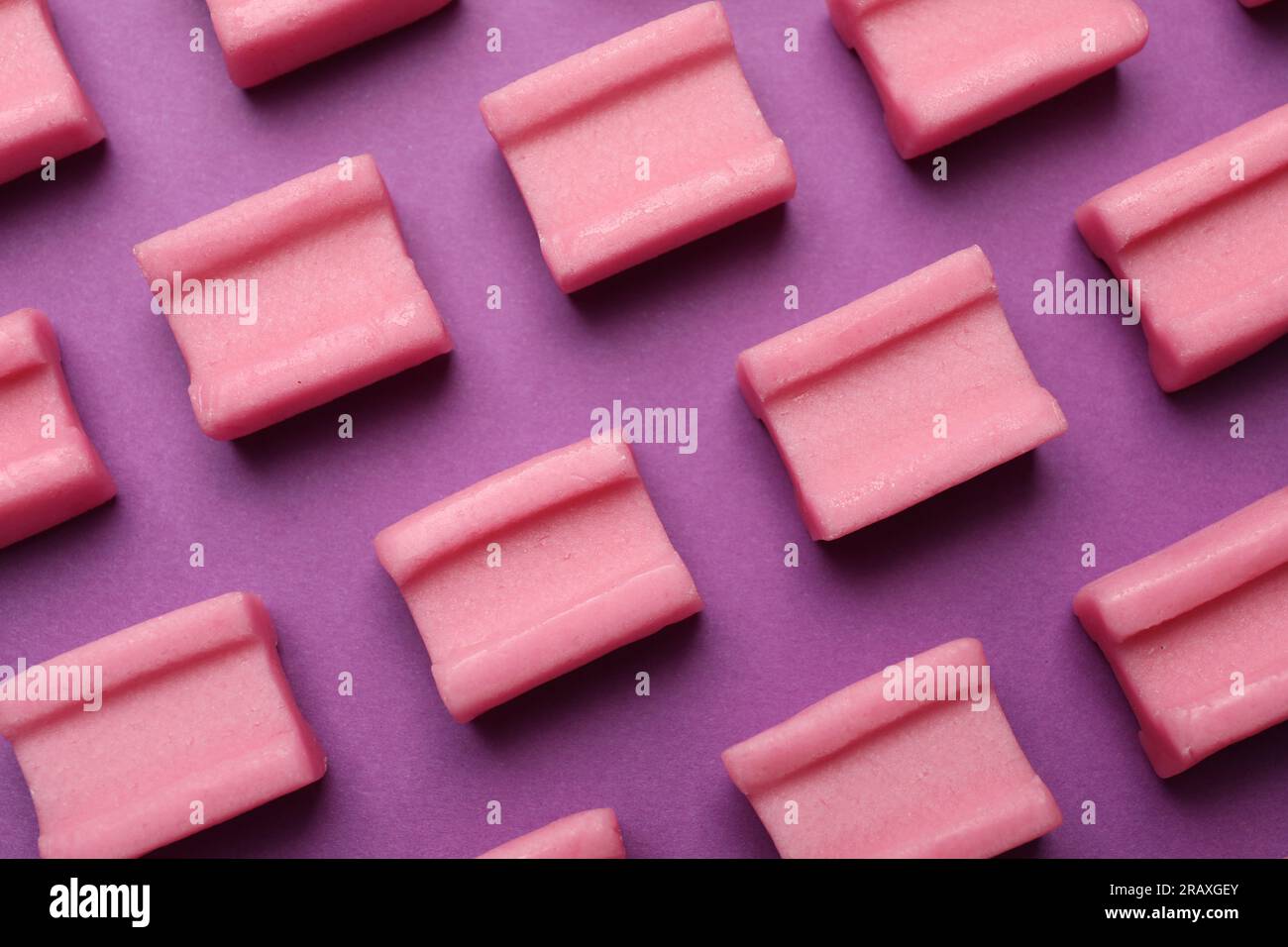 Tasty pink chewing gums on purple background, flat lay Stock Photo - Alamy