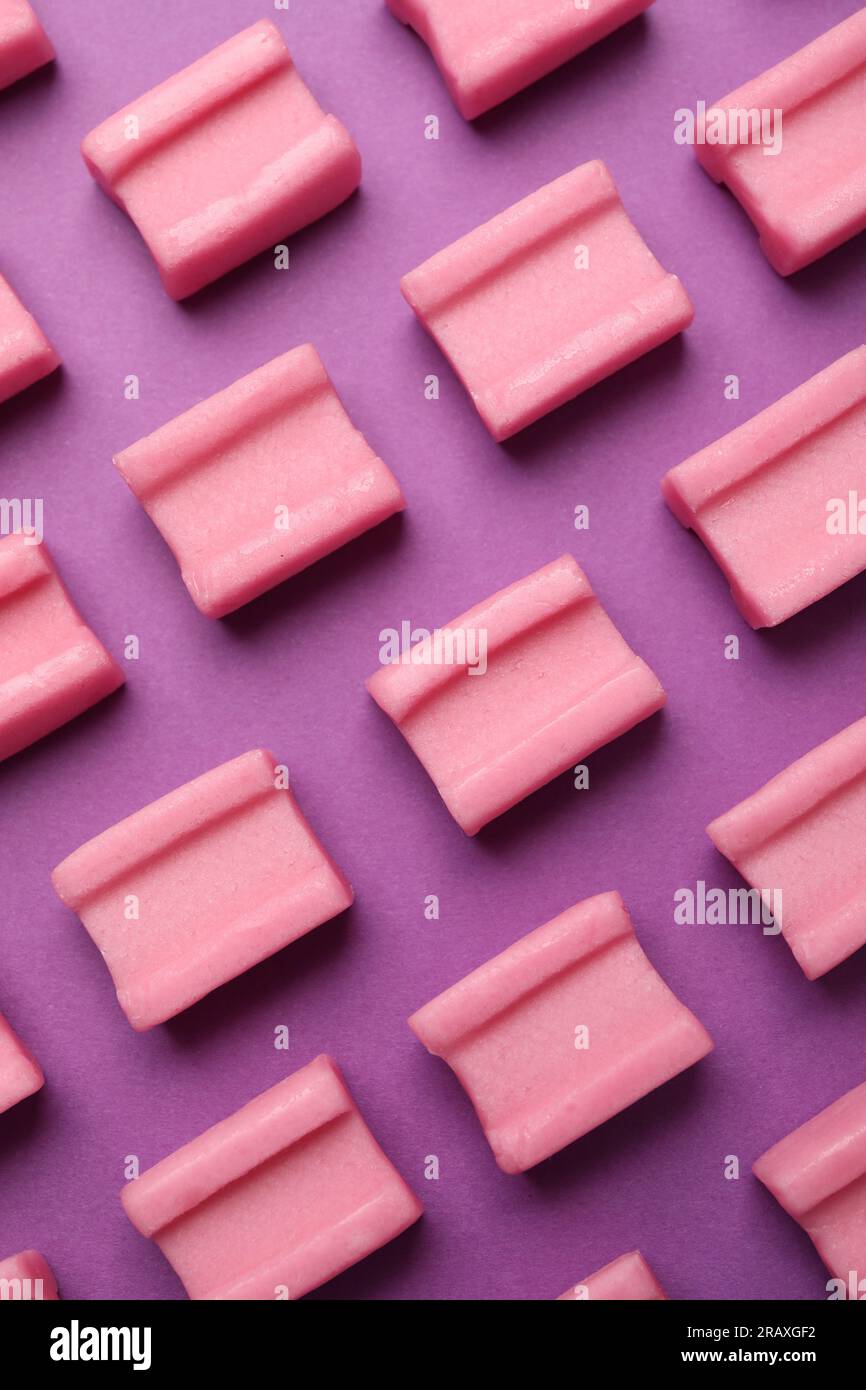 Tasty pink chewing gums on purple background, flat lay Stock Photo - Alamy
