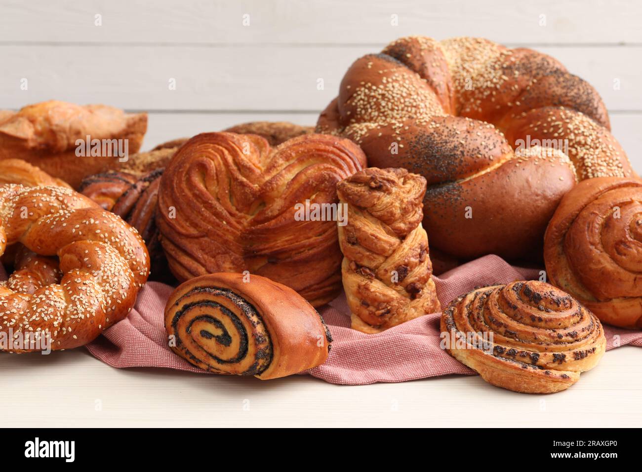 Different tasty freshly baked pastries on white table Stock Photo - Alamy