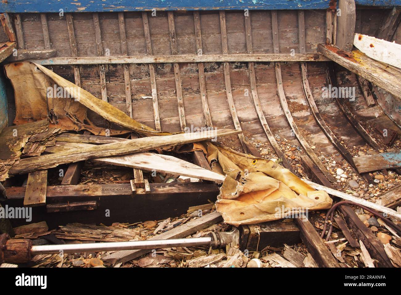 The inside of an old discarded fishing boat on the shingle beach at ...