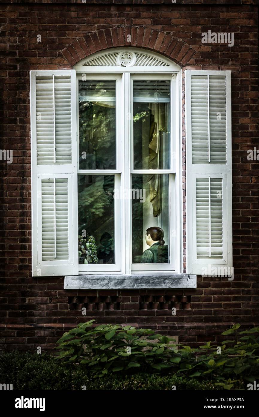 Dummy sitting figure seen in the window of a Victorian mansion Stock ...