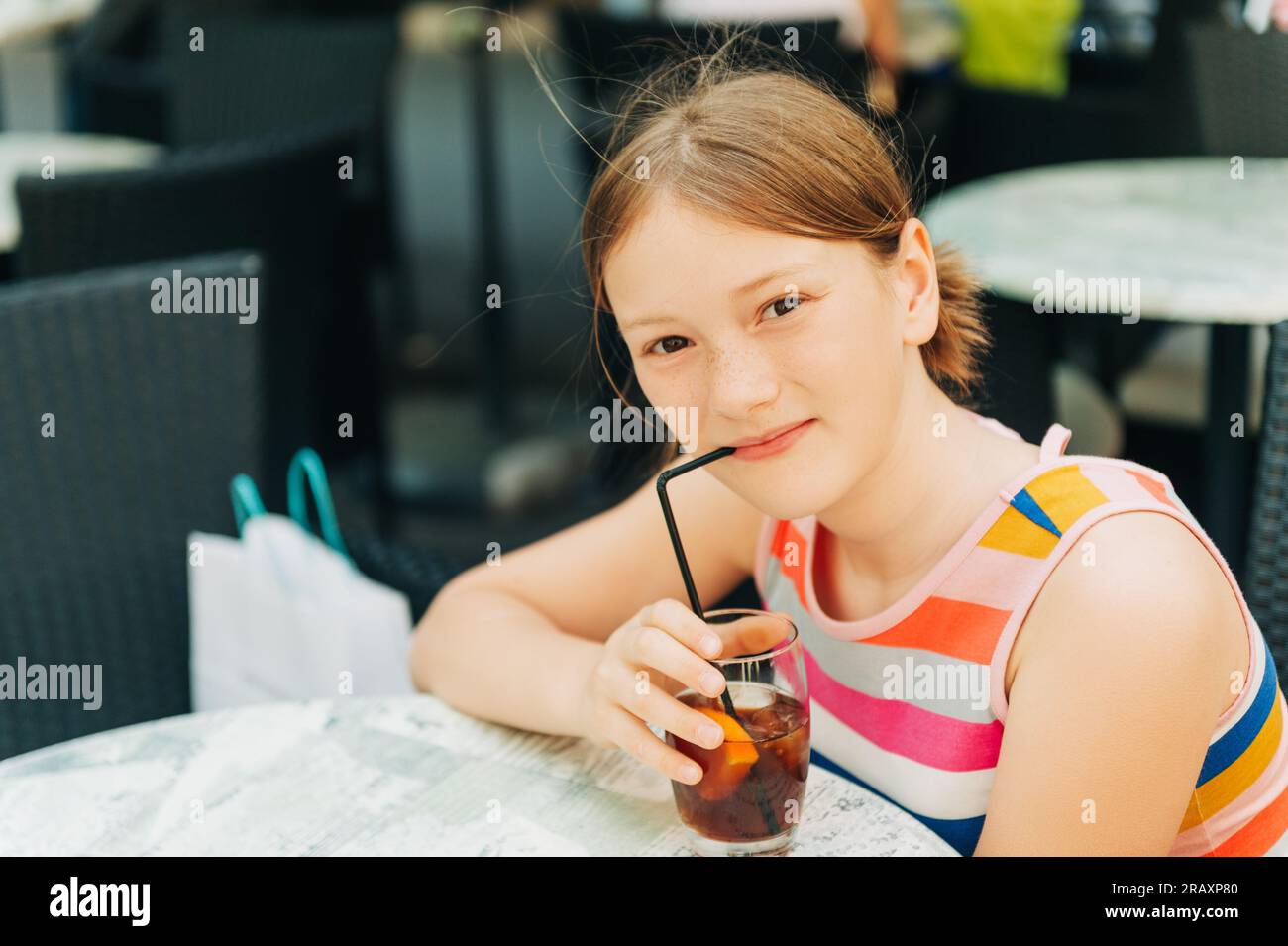 Little girl drinking ice tea in outside cafe Stock Photo - Alamy