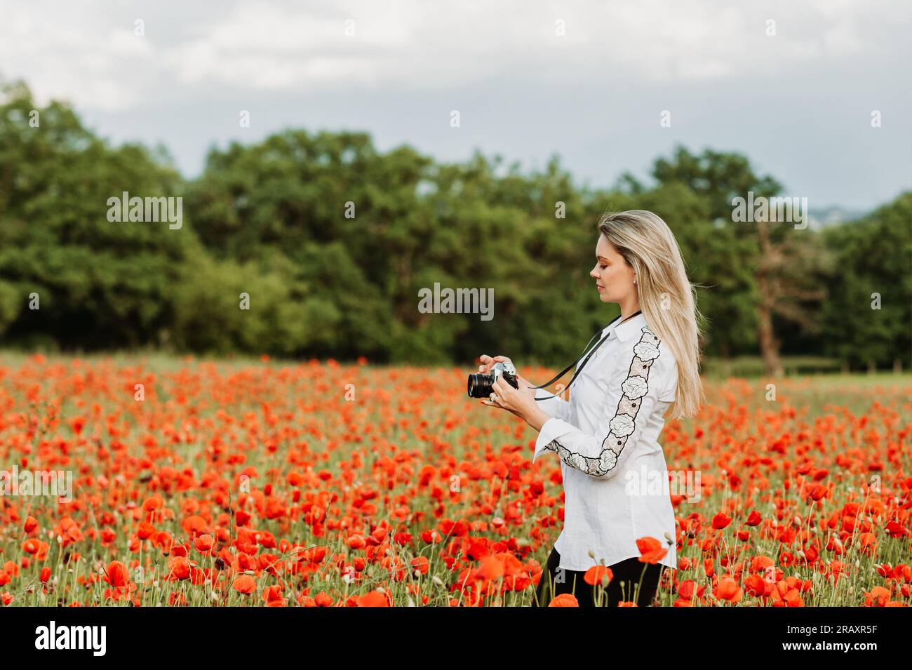 Beautiful woman photographer enjoying amazing day at poppy field ...