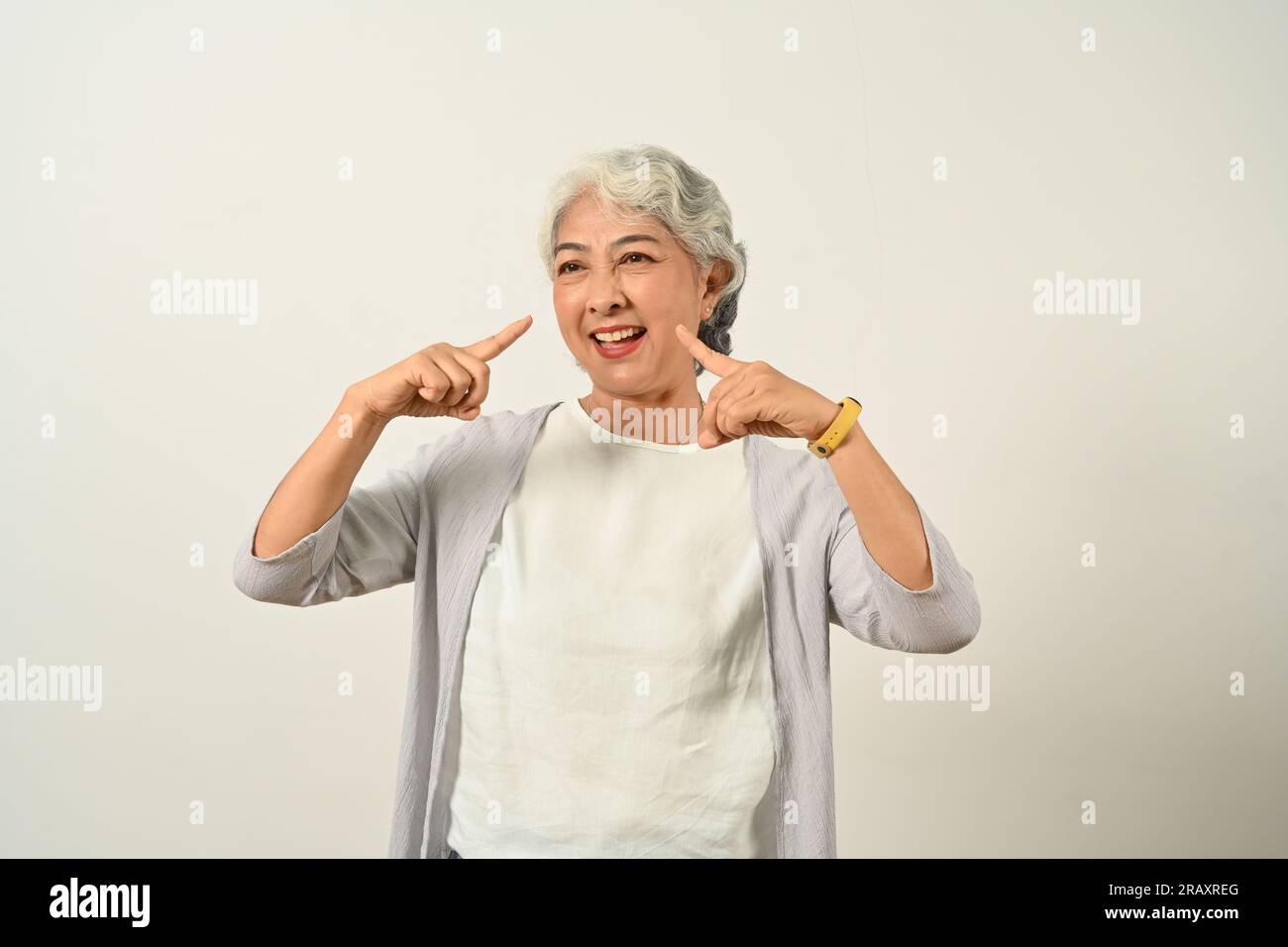 Nice gray haired senior woman posing with smiling face over white ...