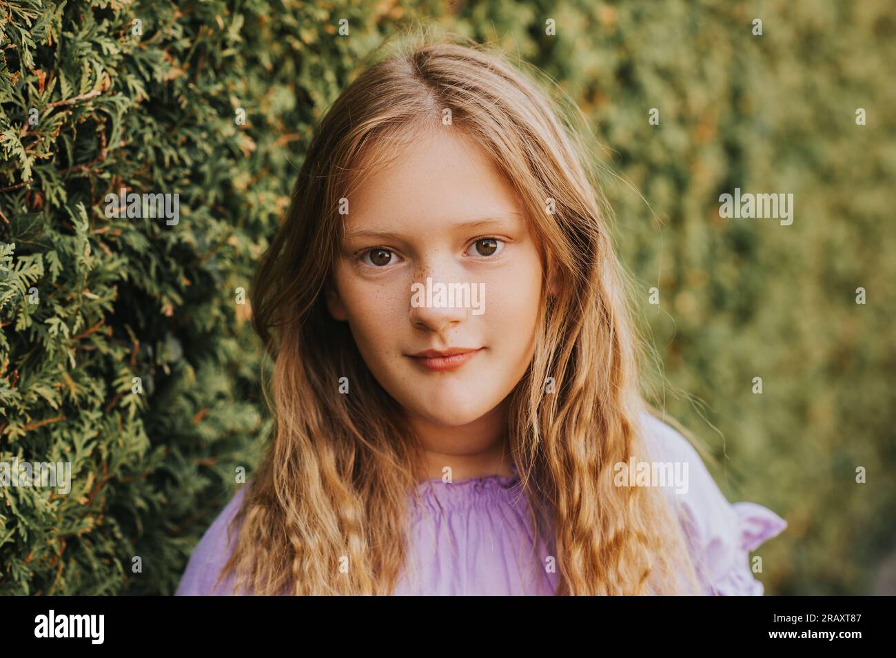 Outdoor portrait of adorable kid girl on green background Stock Photo ...