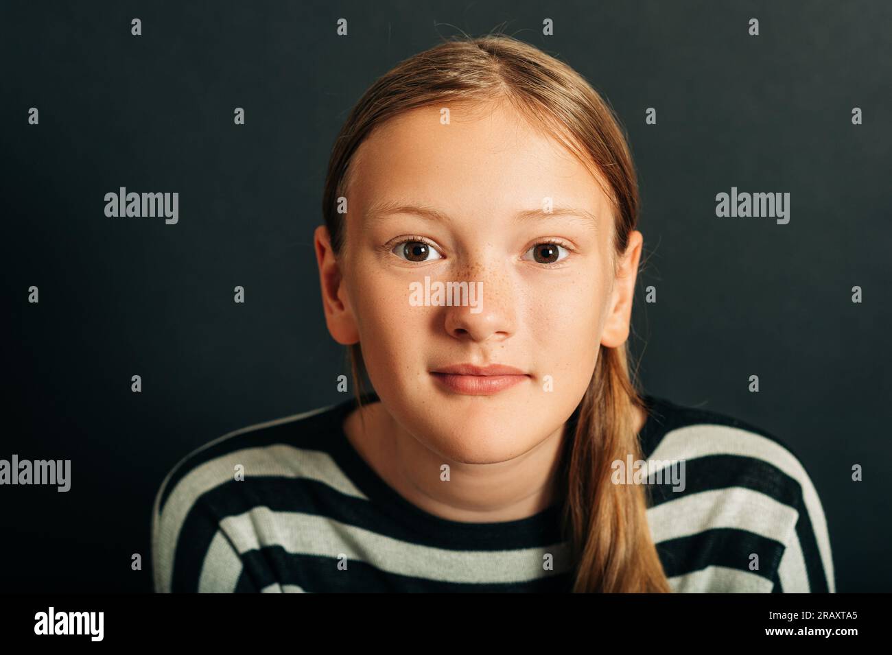 Dark studio portrait of young kid girl wearing stripe pullover Stock ...