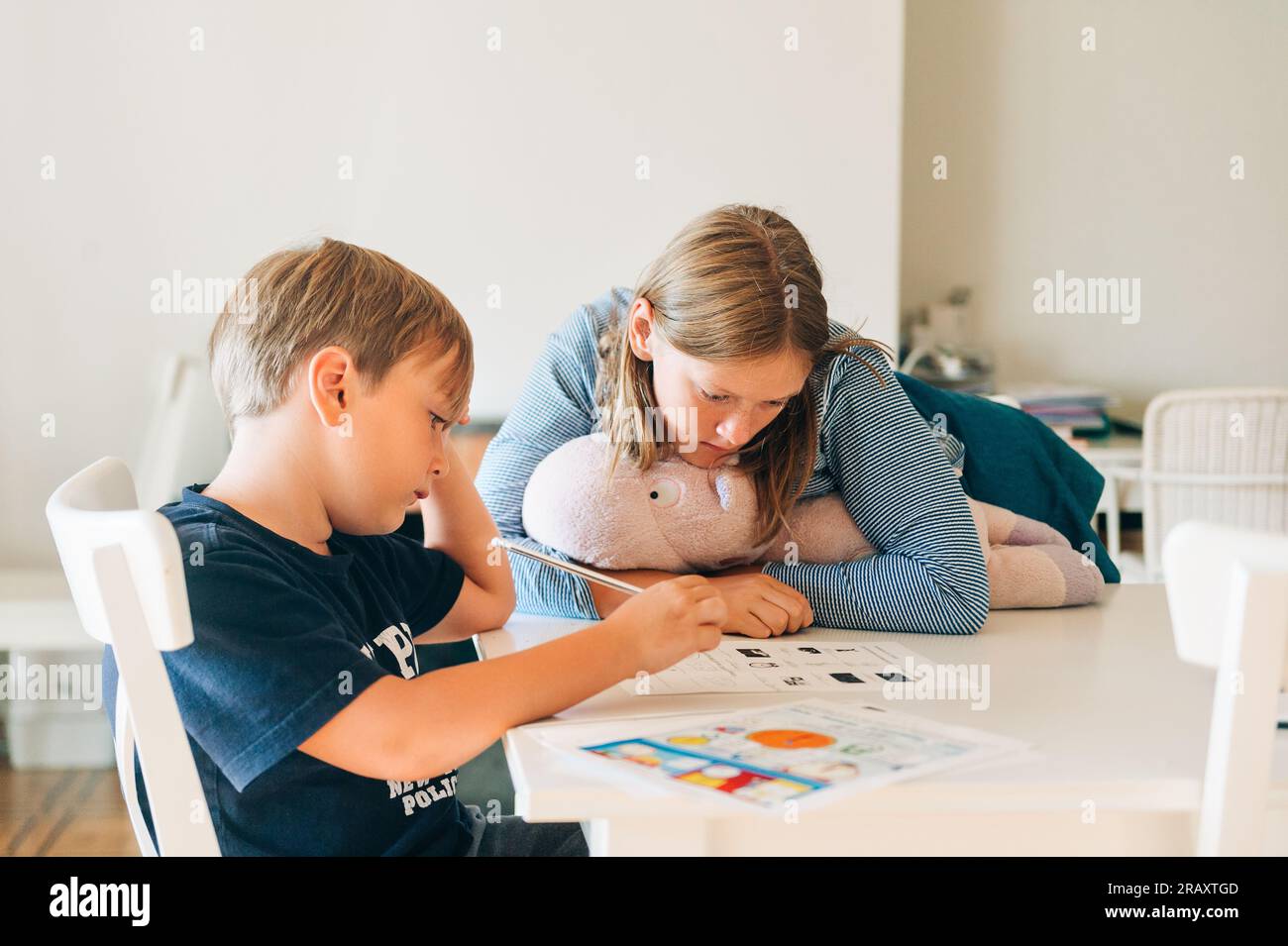 Big sister helping little brother with school homework Stock Photo - Alamy