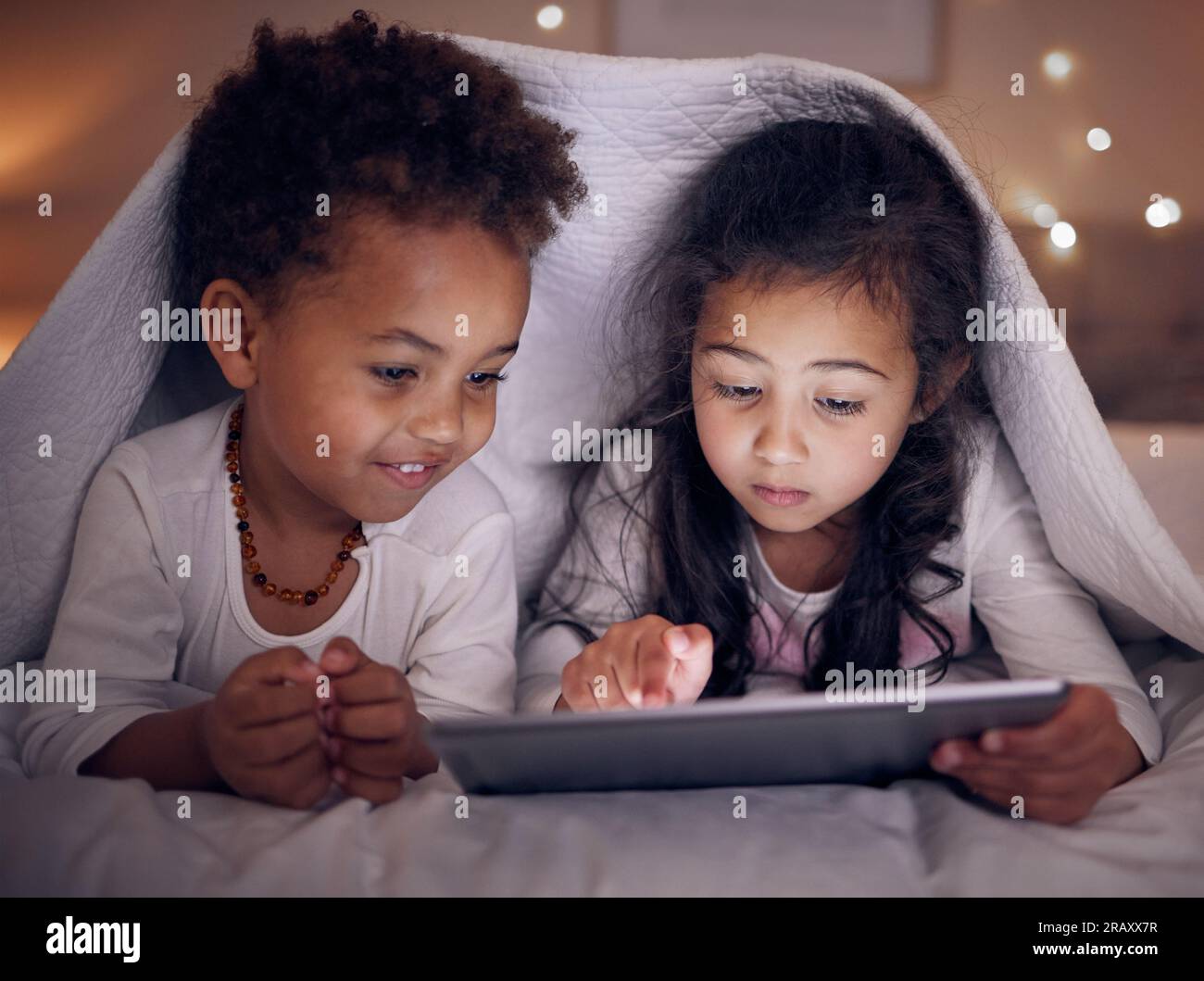 Games, night and children with a tablet in bed for cartoon, movie or ...